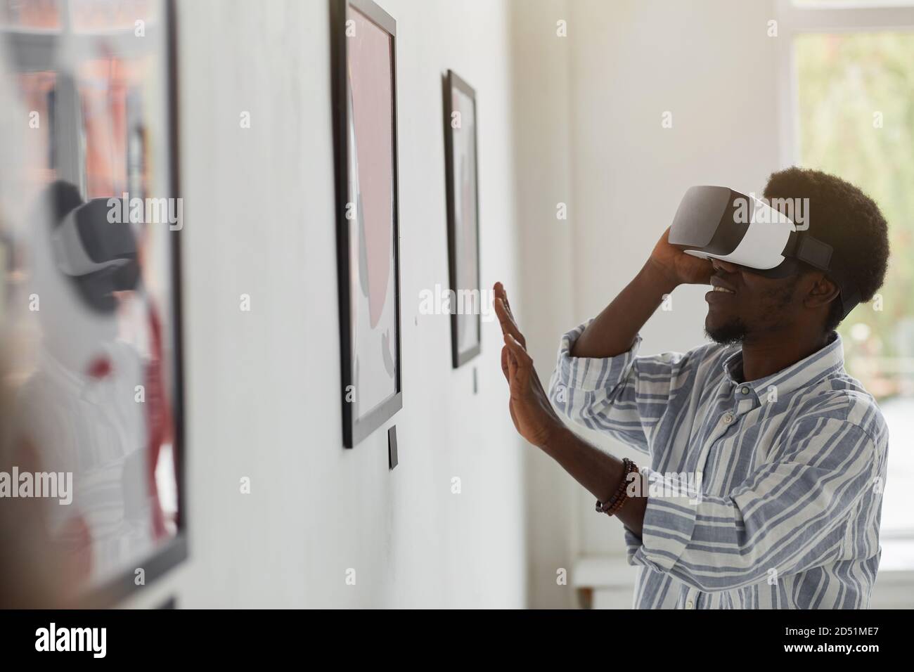 Side view portrait of smiling African-American man wearing VR gear ...