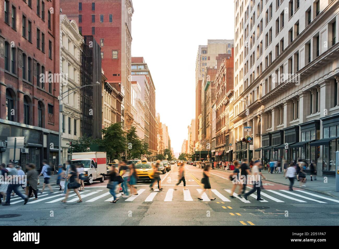 Crowds of people walking through a busy crosswalk at the intersection ...