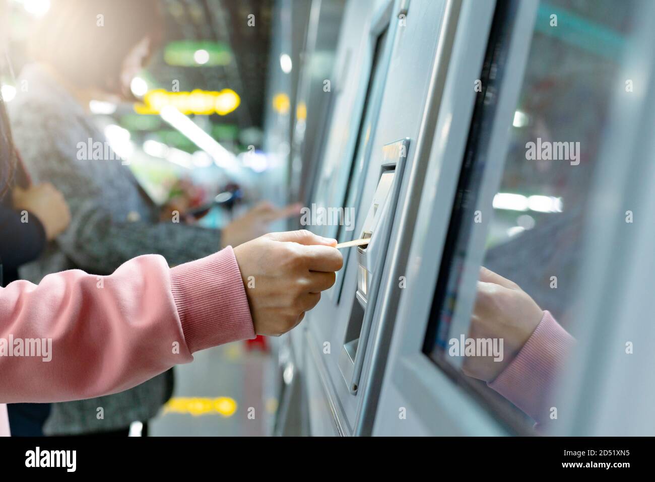 Woman take a train ticket after buy from subway ticket machine ...