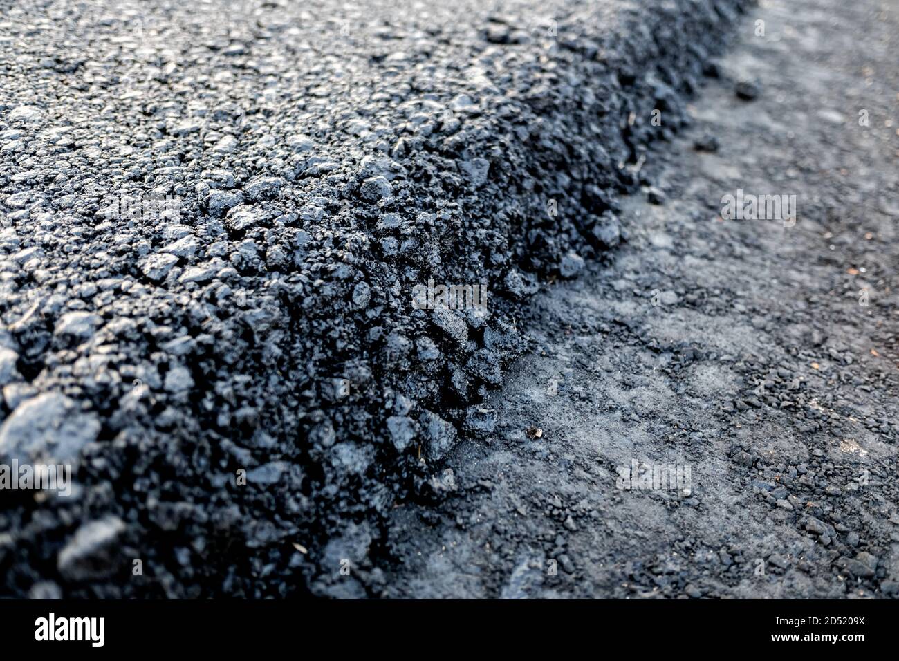 Asphalt layer just spread on a new road, detail Stock Photo - Alamy