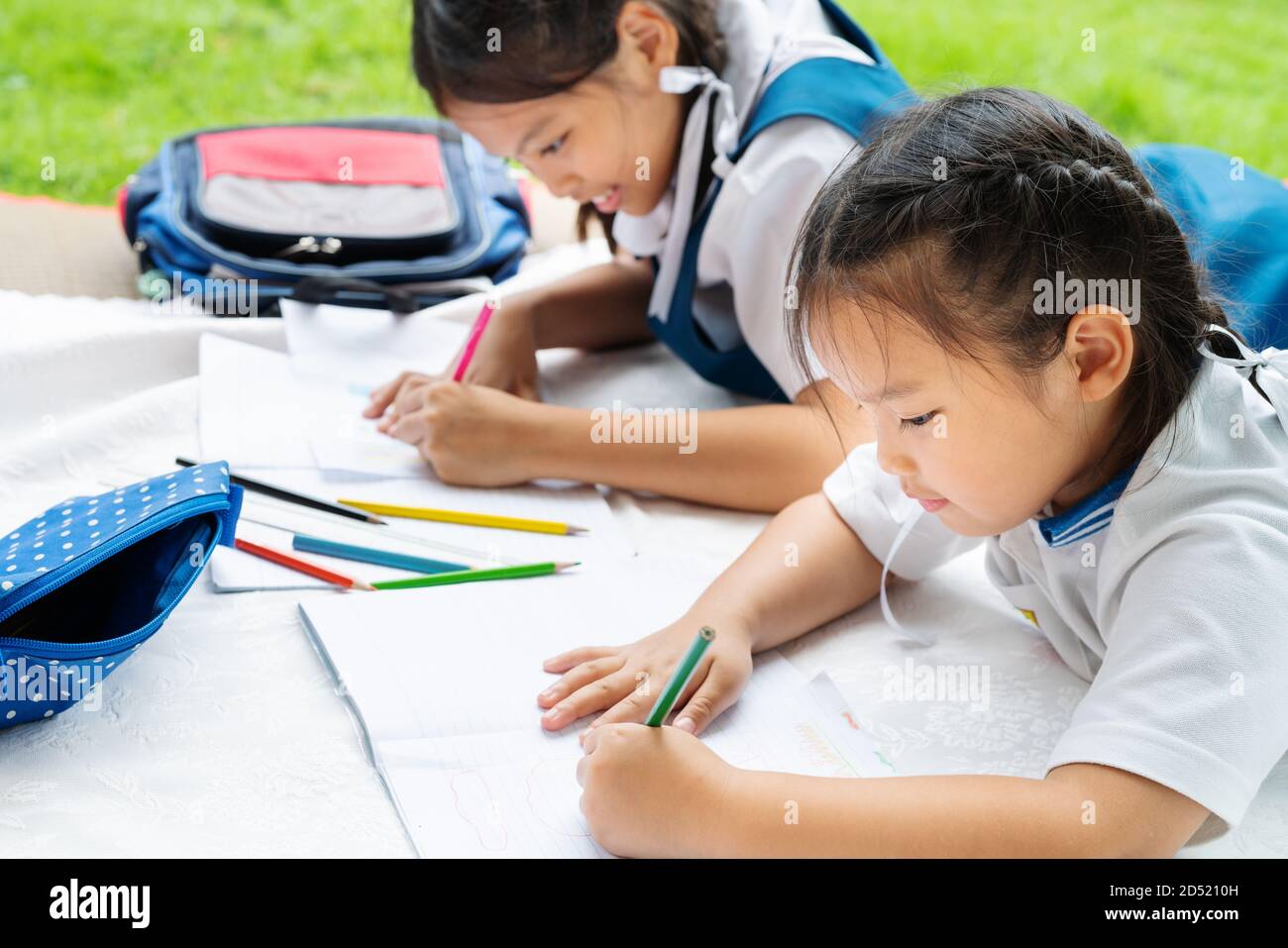 two sister girl writes to writing-books. The decision of lessons. girl ...
