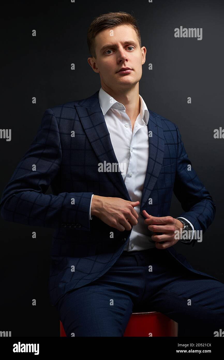 young influential oil tycoon sits on oil barrel isolated over black ...