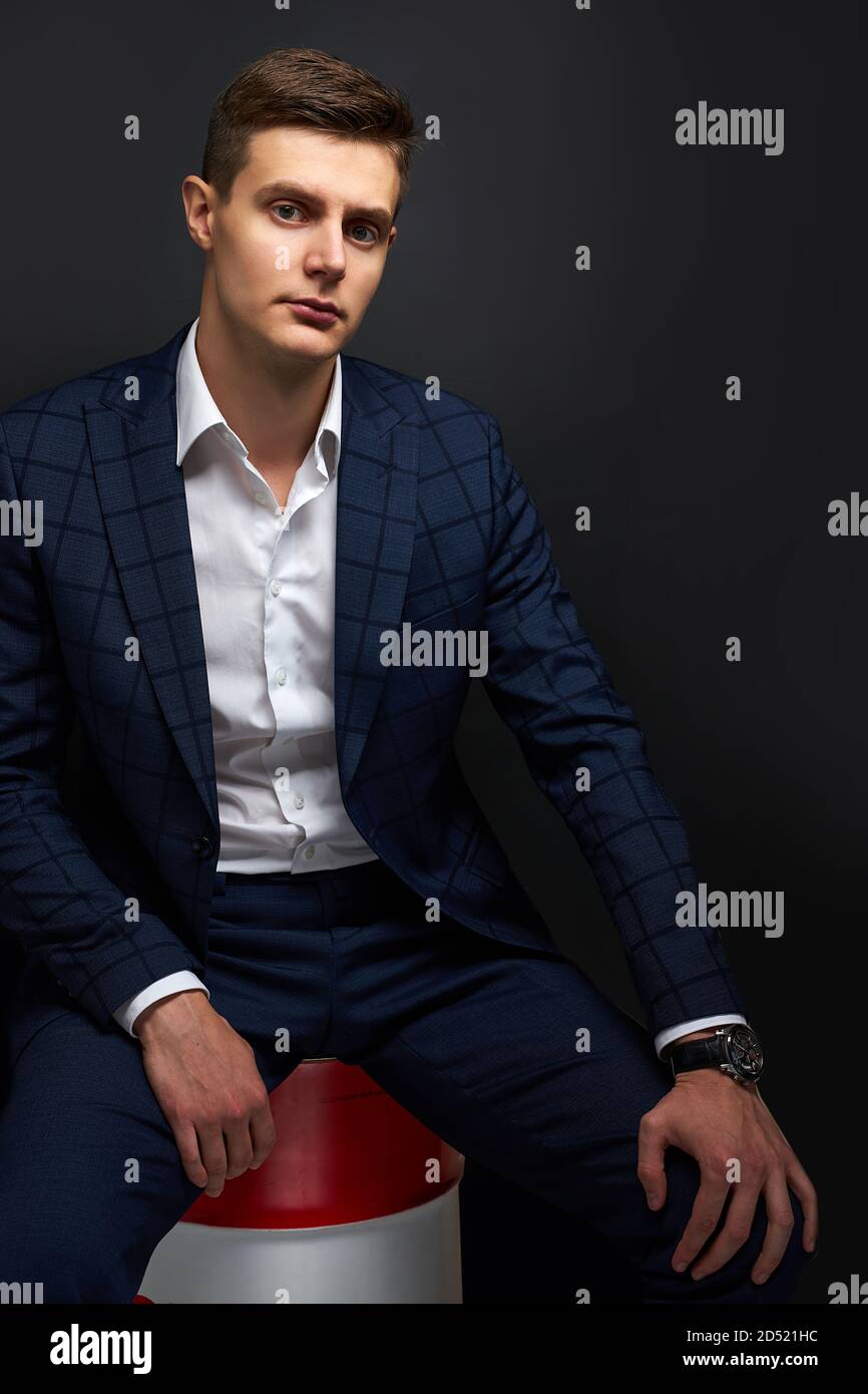 young influential oil tycoon sits on oil barrel isolated over black ...