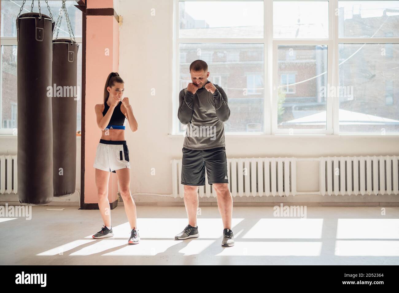 A young attractive boxing coach prepares a pretty girl for competition ...