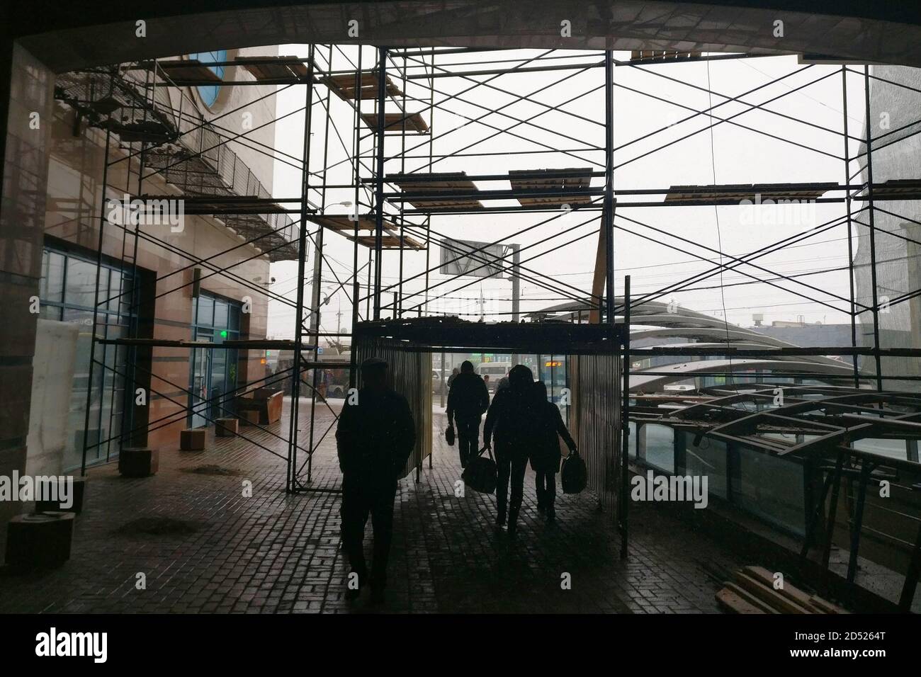 Scaffolding in the pedestrian area. People go next to the building ...