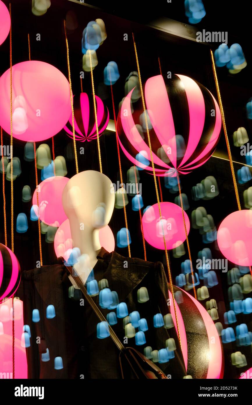 Night shop window with inflatable balls. Flashlights are reflected in ...