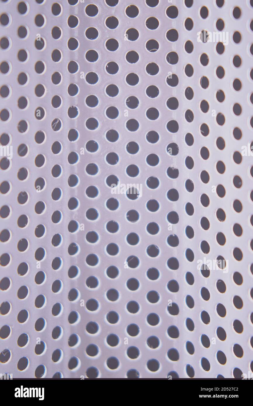 Texture in the form of a curved mesh grid with round holes, close-up ...