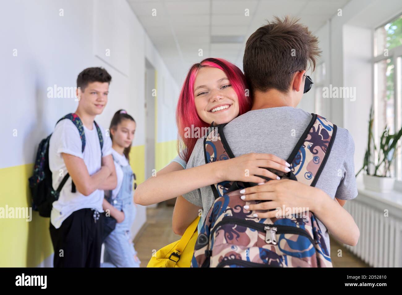 Hugging greeted teenagers at school, happy smiling face of girl hugging ...