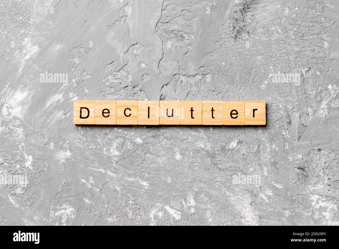 Declutter word written on wood block. Declutter text on cement table ...