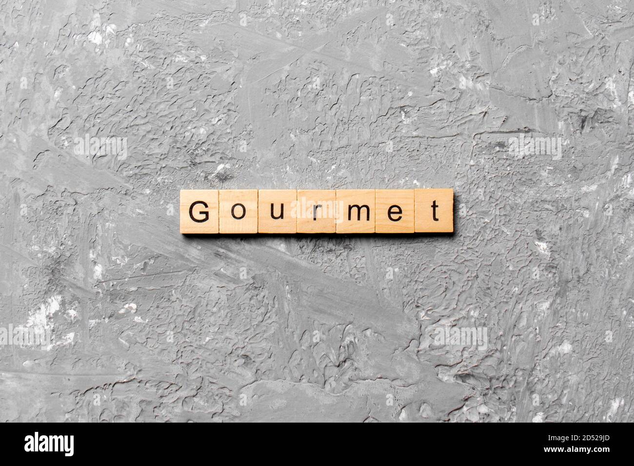 gourmet word written on wood block. gourmet text on cement table for ...