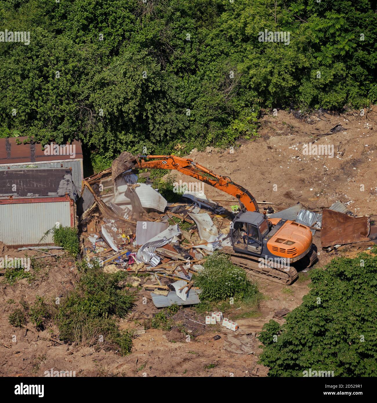 Destruction of an illegally constructed old building using an excavator ...
