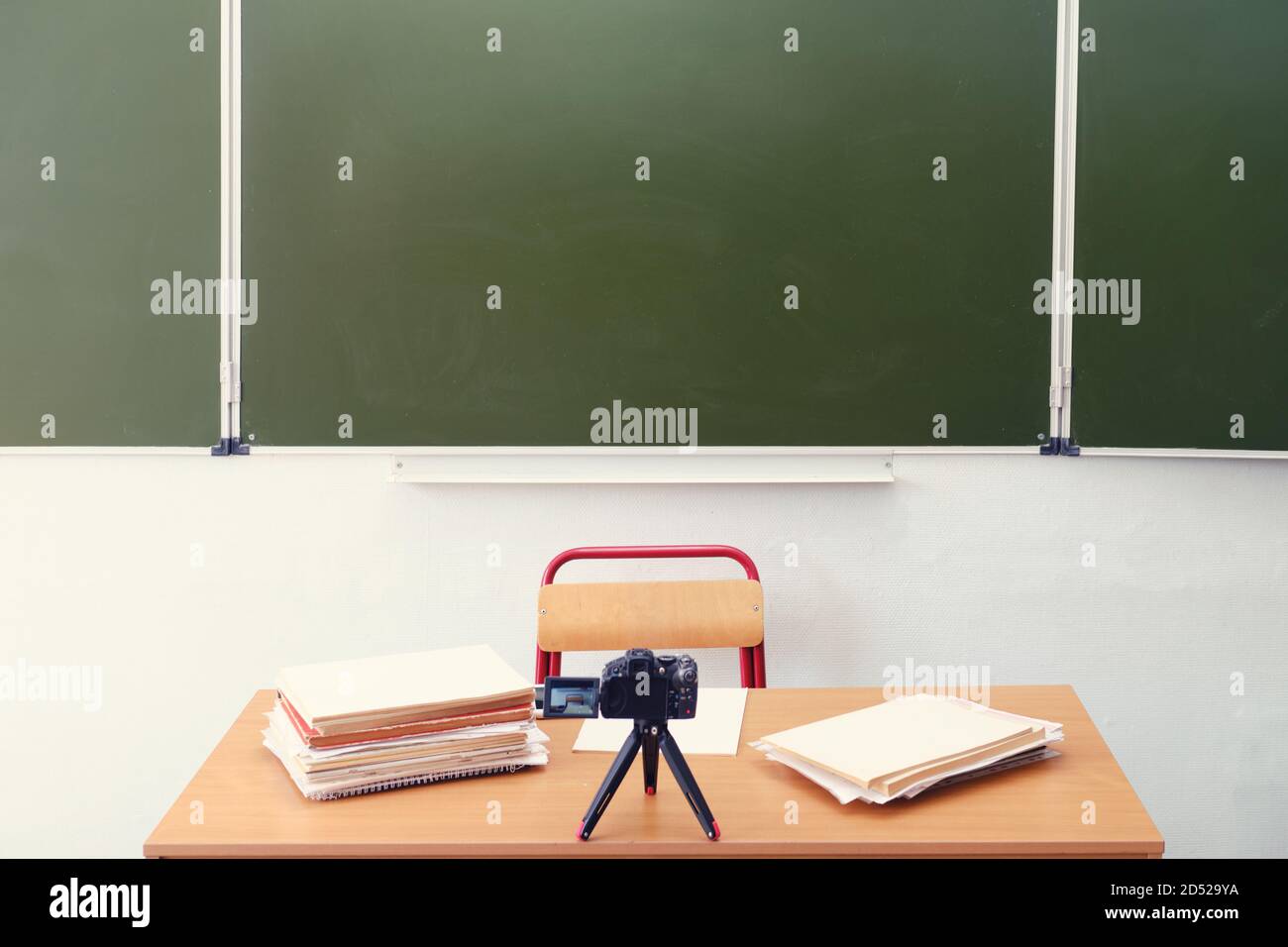 Teacher desk, blackboard and a video camera filming an online lesson ...