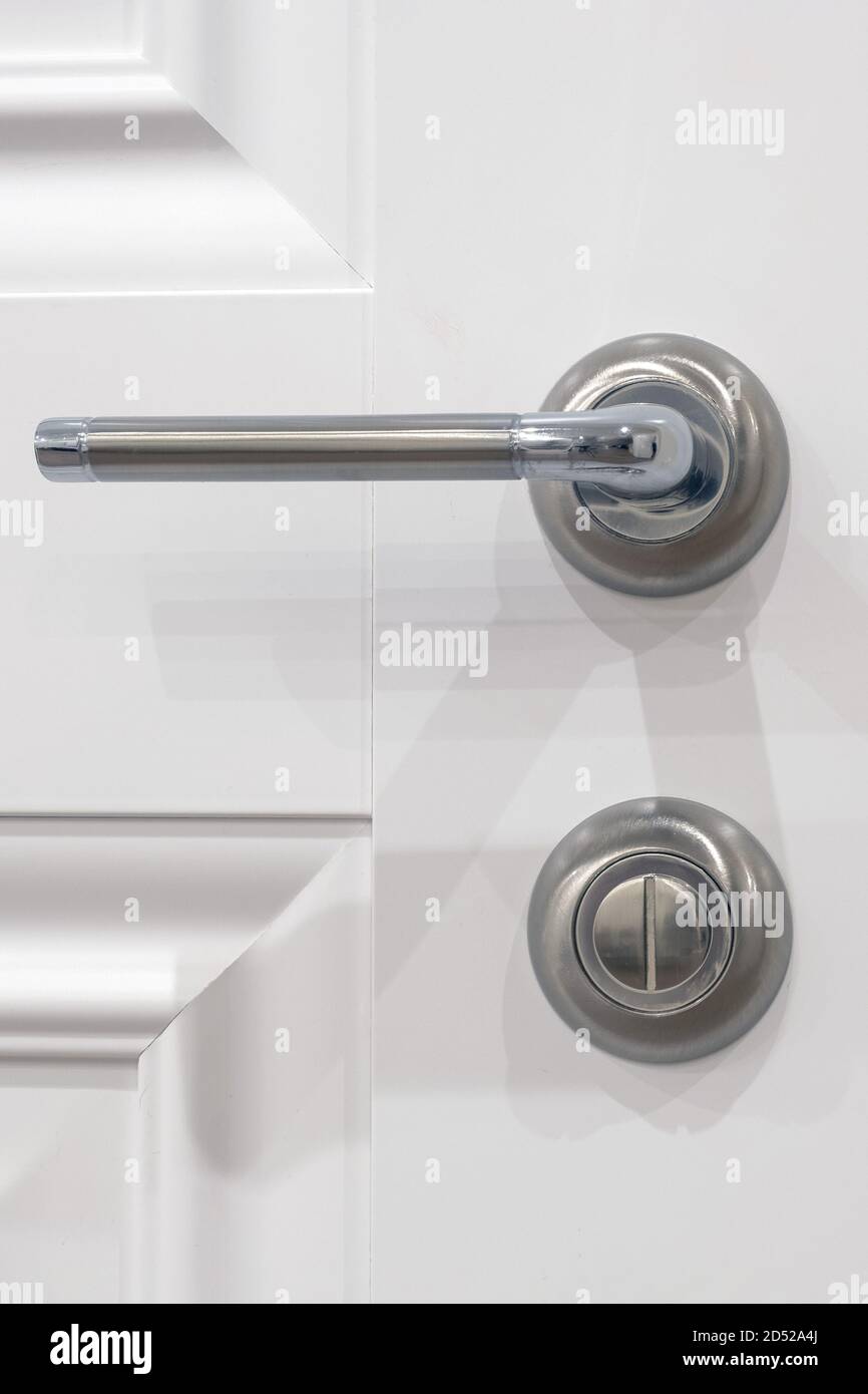 Metal handle with a rotary lock on a white door, close-up Stock Photo ...