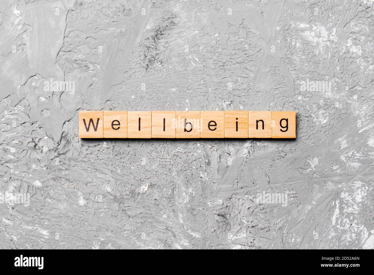 Wellbeing word written on wood block. Wellbeing text on cement table ...