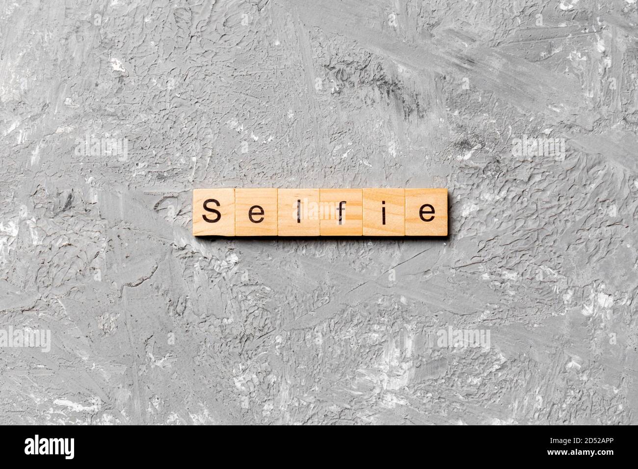 selfie word written on wood block. selfie text on cement table for your ...
