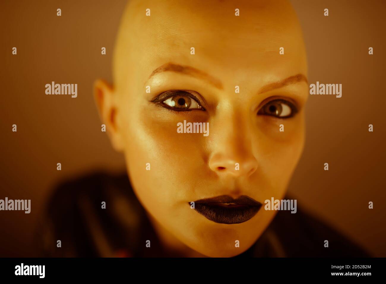 Emotive portrait of a beautiful bald woman while standing in the studio ...