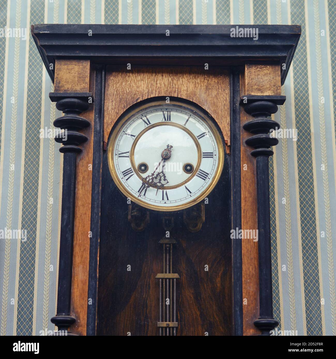 Old wall clock on the wall with wallpaper, close up Stock Photo - Alamy