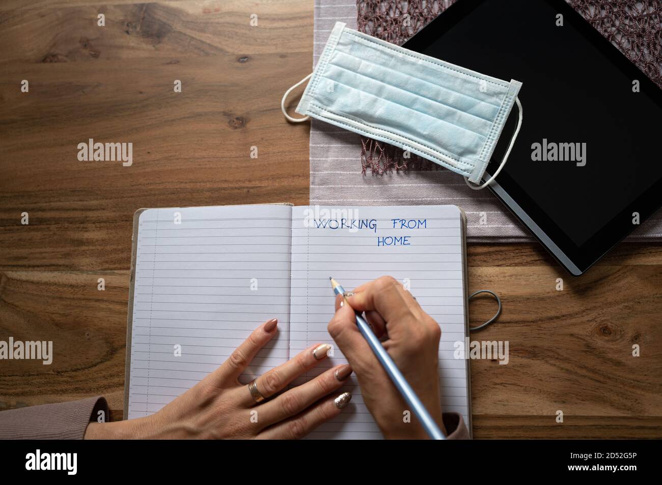 Working from home conceptual image - top view of female hands writing ...