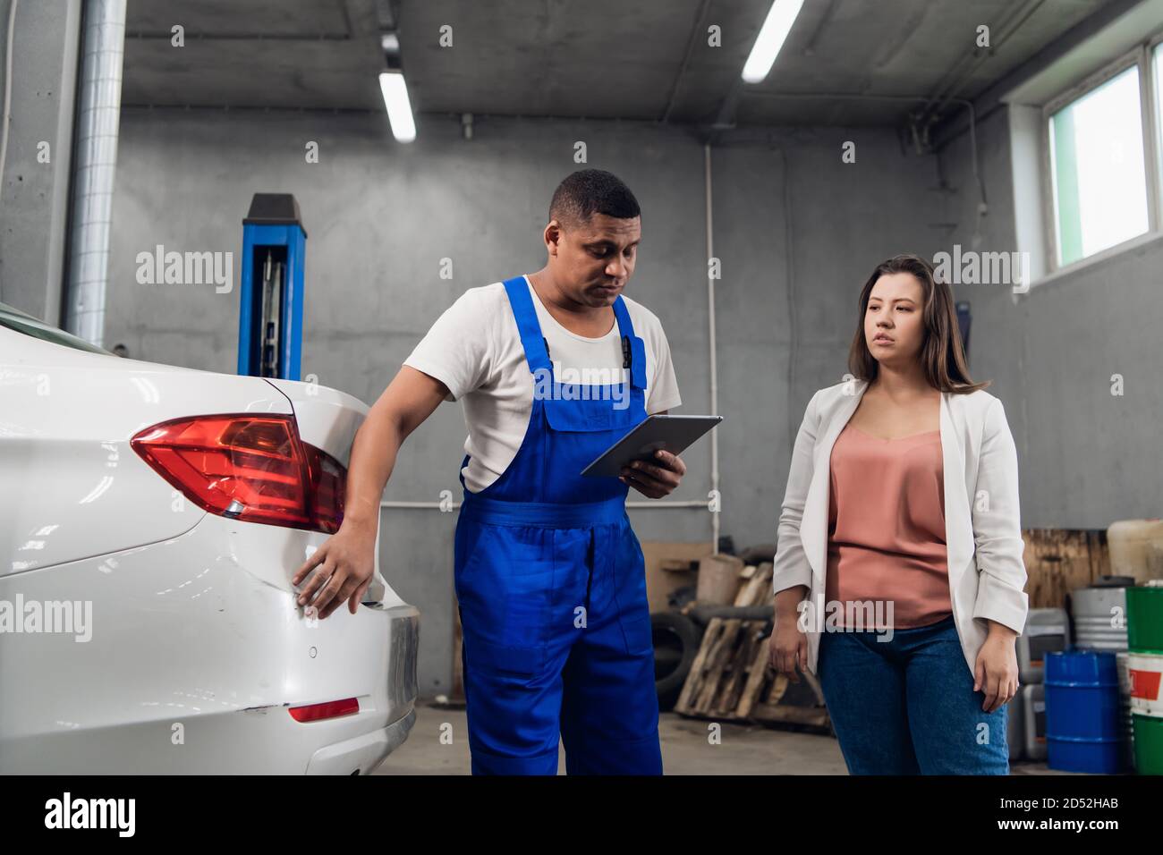 Mechanic talking with customer about car repair Stock Photo - Alamy
