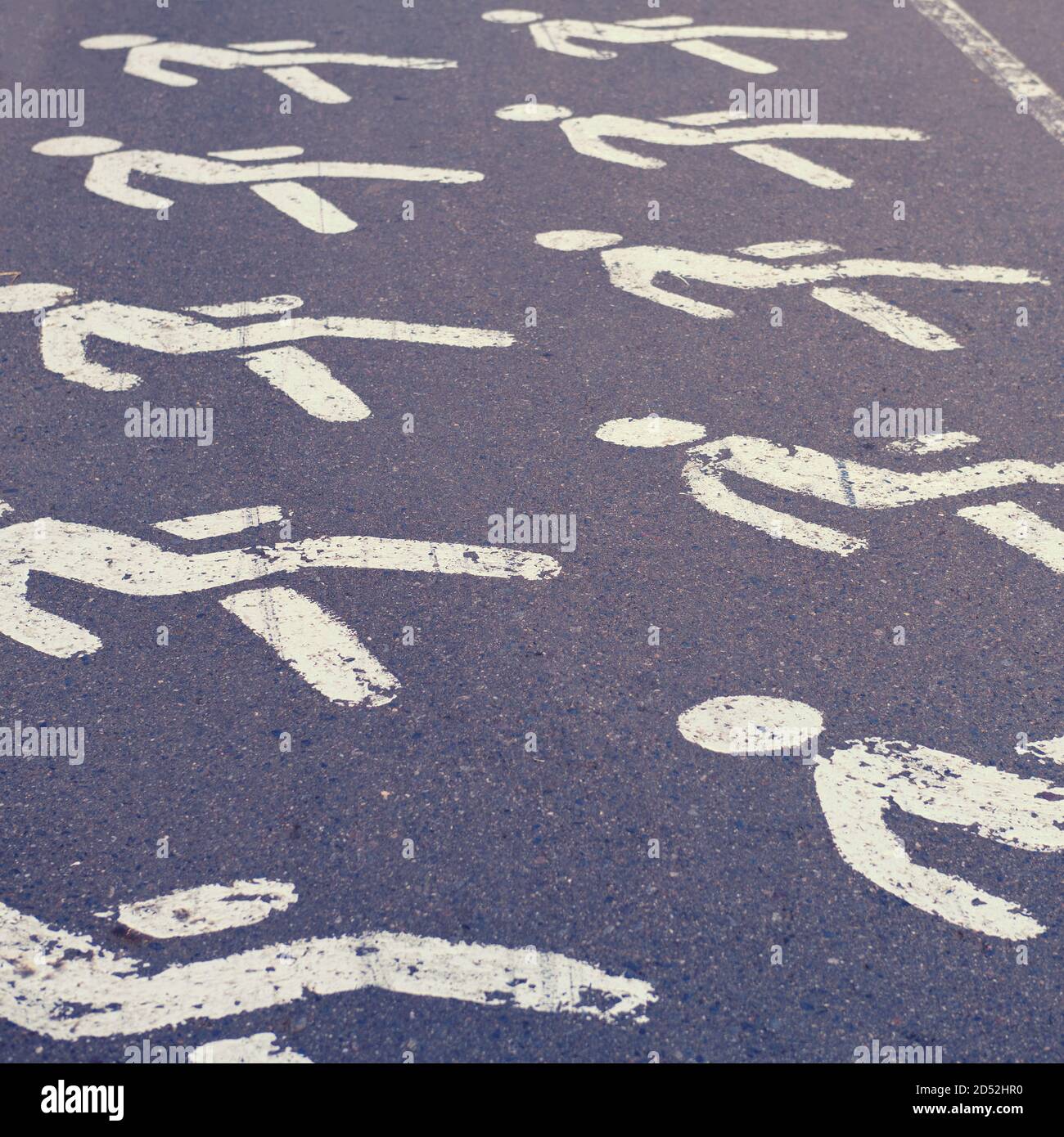 Pedestrian crossing sign in the form of a drawn man on the asphalt ...