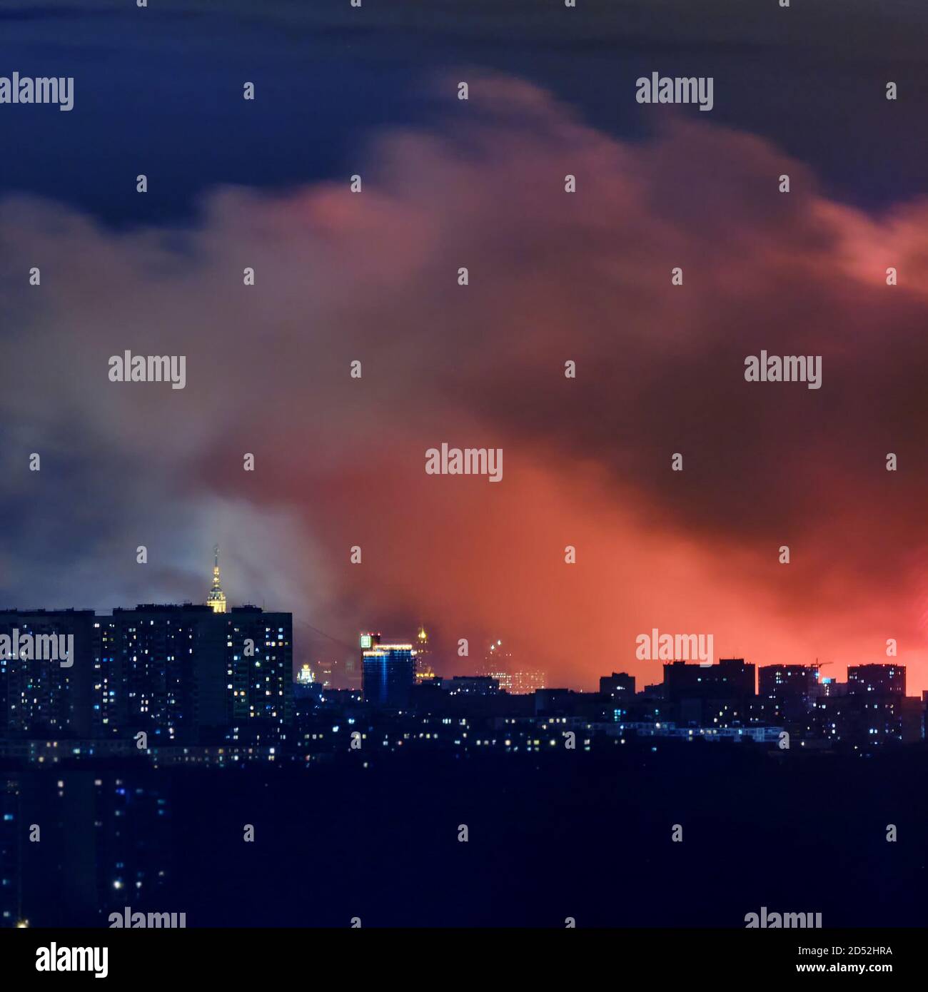 Smoke and fire over the night city. Building is burned and collapsed ...