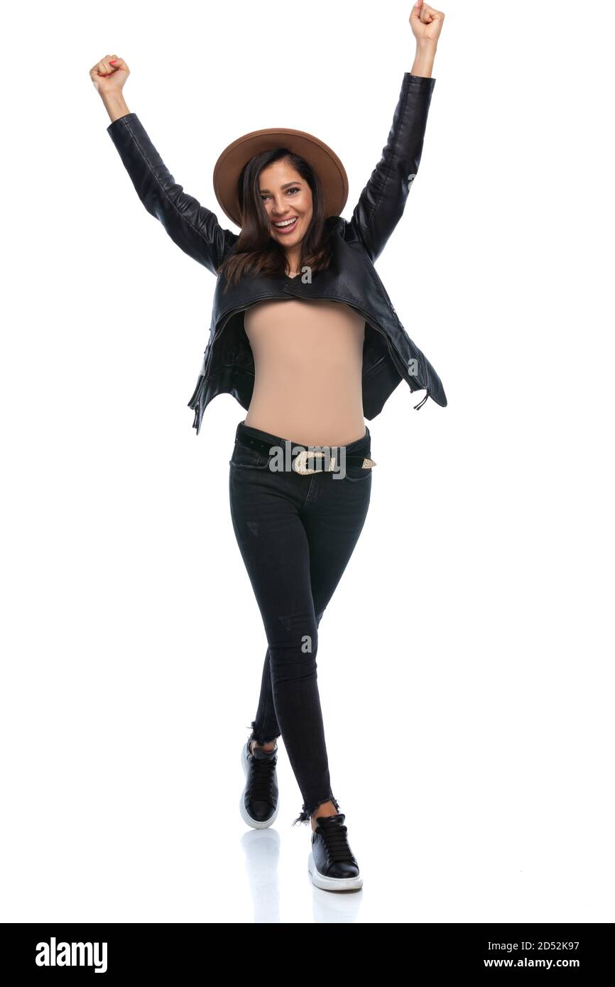 Cheerful casual woman celebrating, wearing hat and leather jacket while ... Cheerful casual woman celebrating, wearing hat and leather jacket while ...