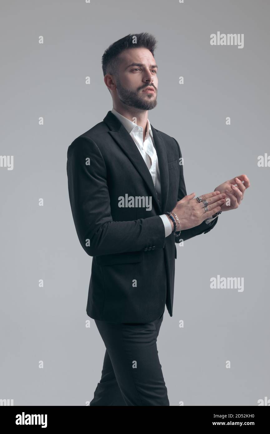 Proud elegant man clapping and looking away, wearing suit while walking ...