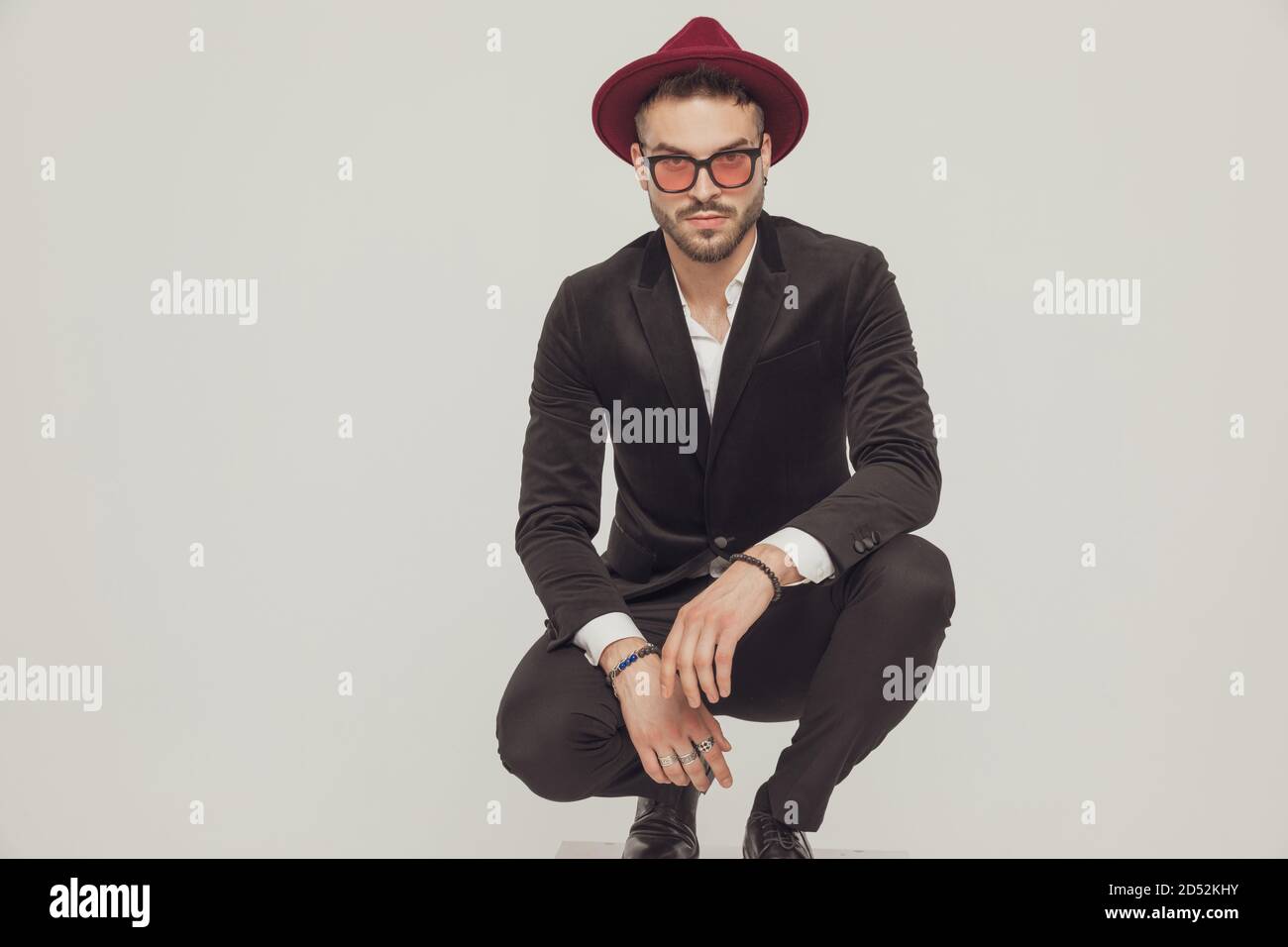 Confident fashion model looking forward, wearing hat and sunglasses ...