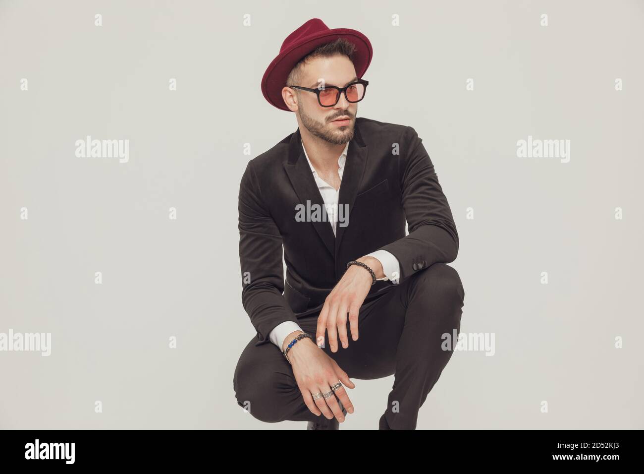 Eager fashion model looking away, wearing hat and sunglasses while ...