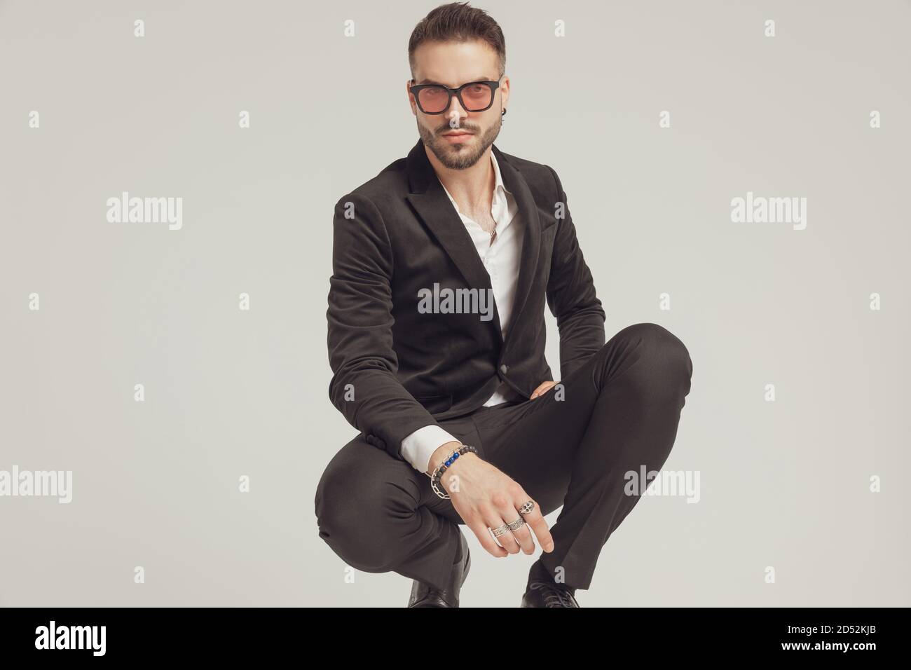 Confident fashion model looking forward and wearing sunglasses while ...