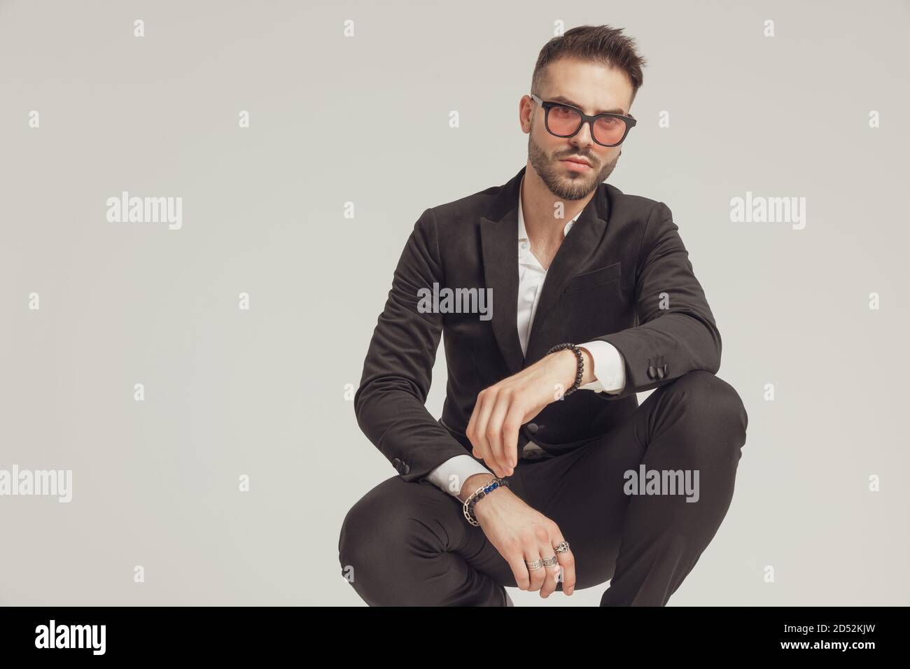 Confident fashion model looking forward and wearing sunglasses while ...