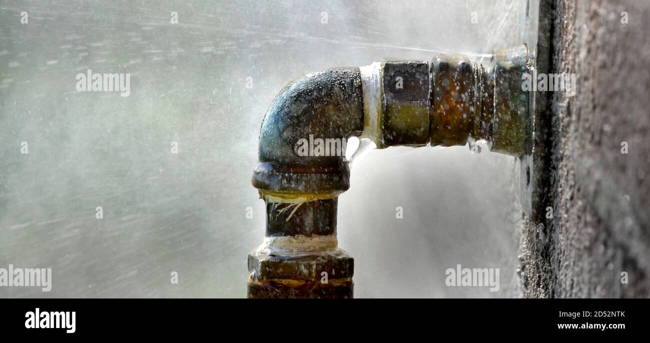 Old rusty pipe with leak and water spraying out Stock Photo - Alamy