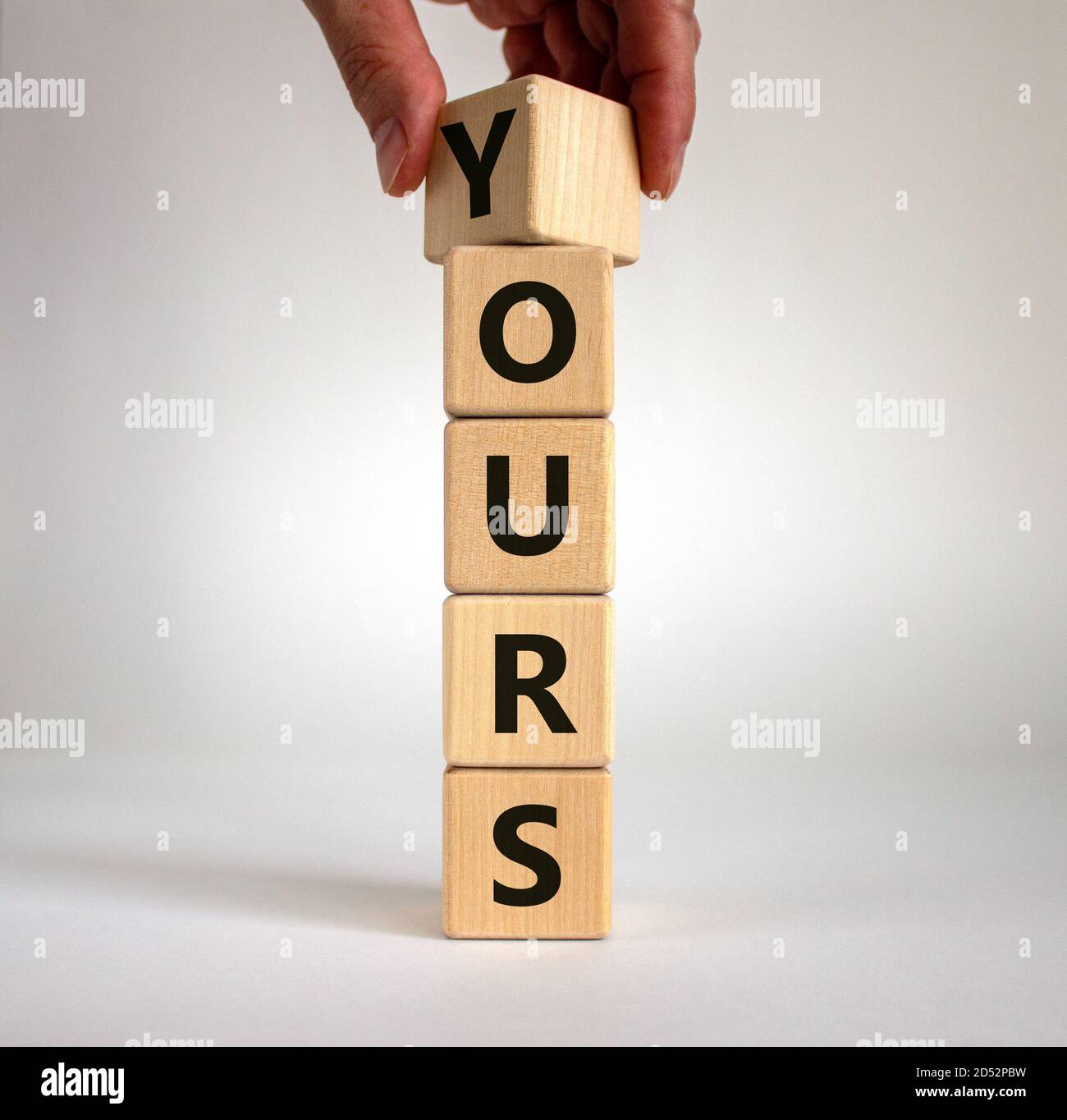 Hand flips a cube and changes the word 'ours' to 'yours'. Beautiful ...