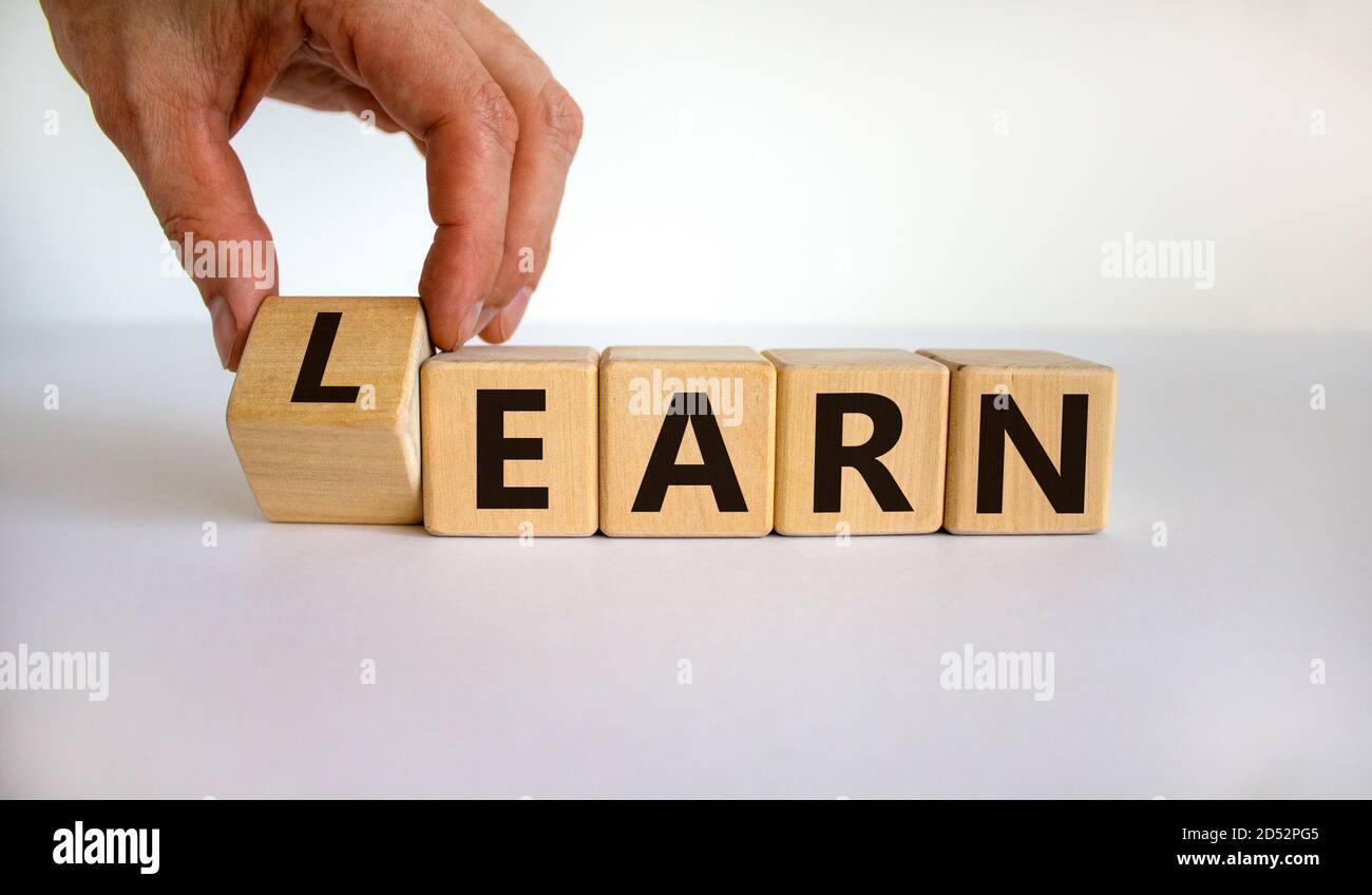 Learn or earn. Hand flips a cube and changes the word 'earn' to 'learn ...