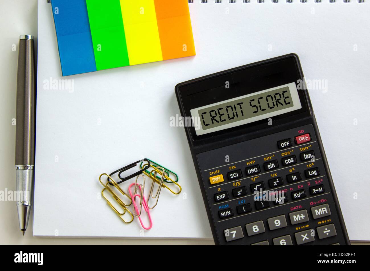 Calculator with inscription 'credit score', white note, colored paper ...