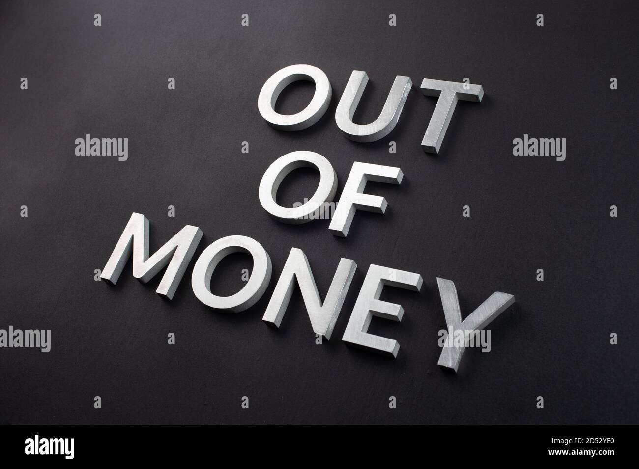 the words out of money laid with white brushed metal letters on flat ...