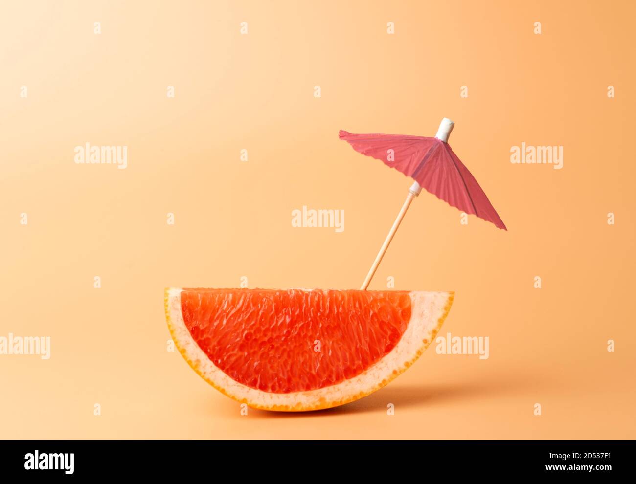 Grapefruit slice on a orange background. Summer, vacation and travel ...