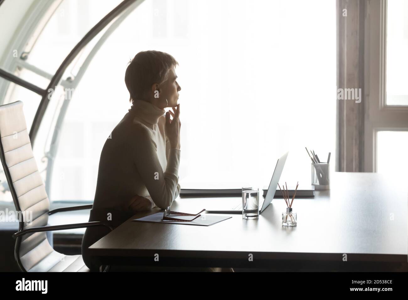 Pensive female employee look in distance thinking Stock Photo - Alamy