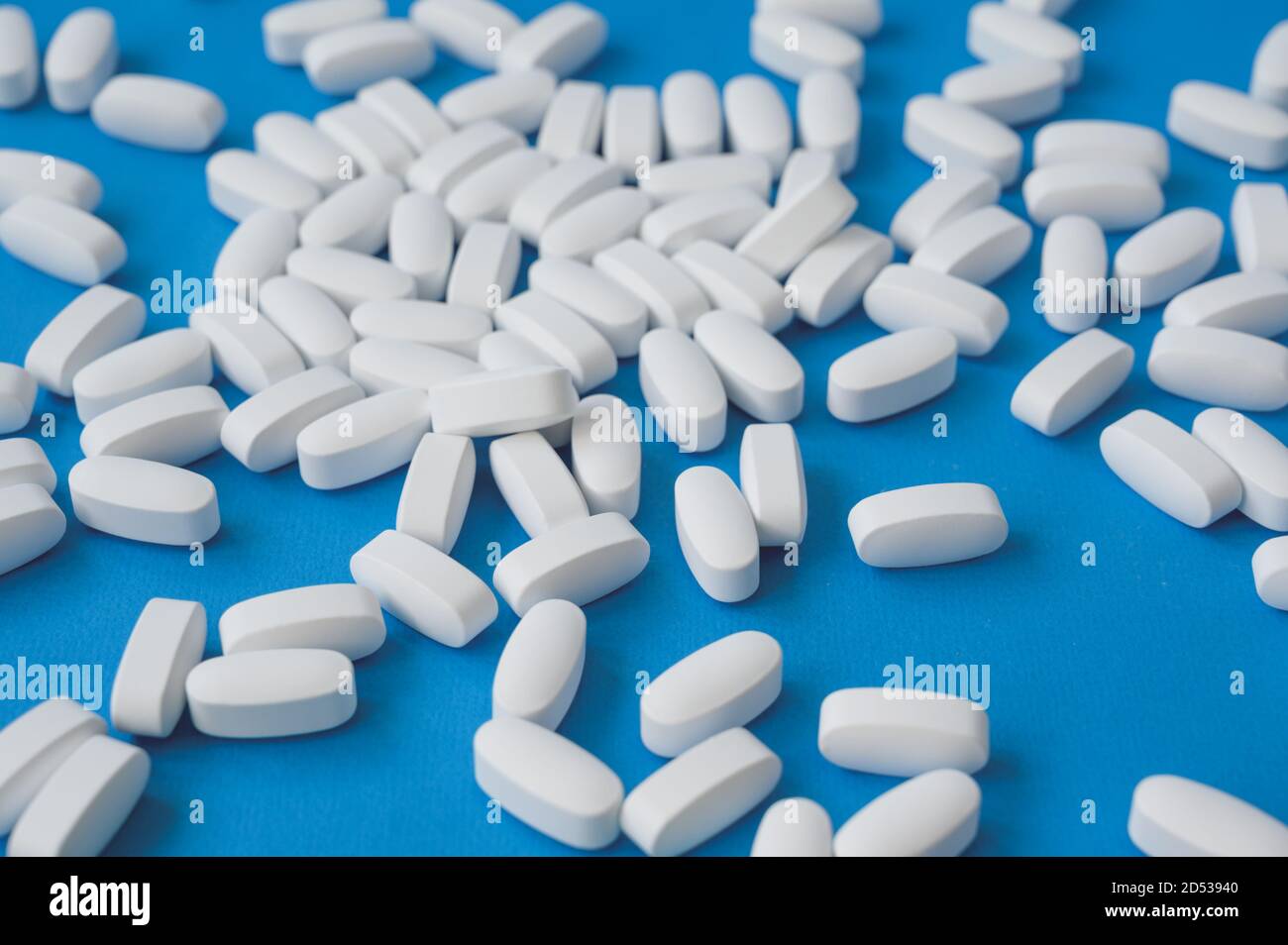 many white clean pills tablets lying on blue surface Stock Photo - Alamy