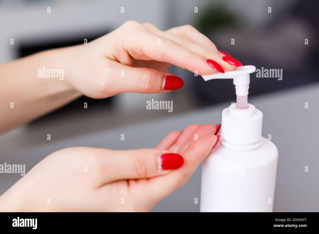 Woman push on dispenser and squeeze out soft soap gel on palm, closeup ...