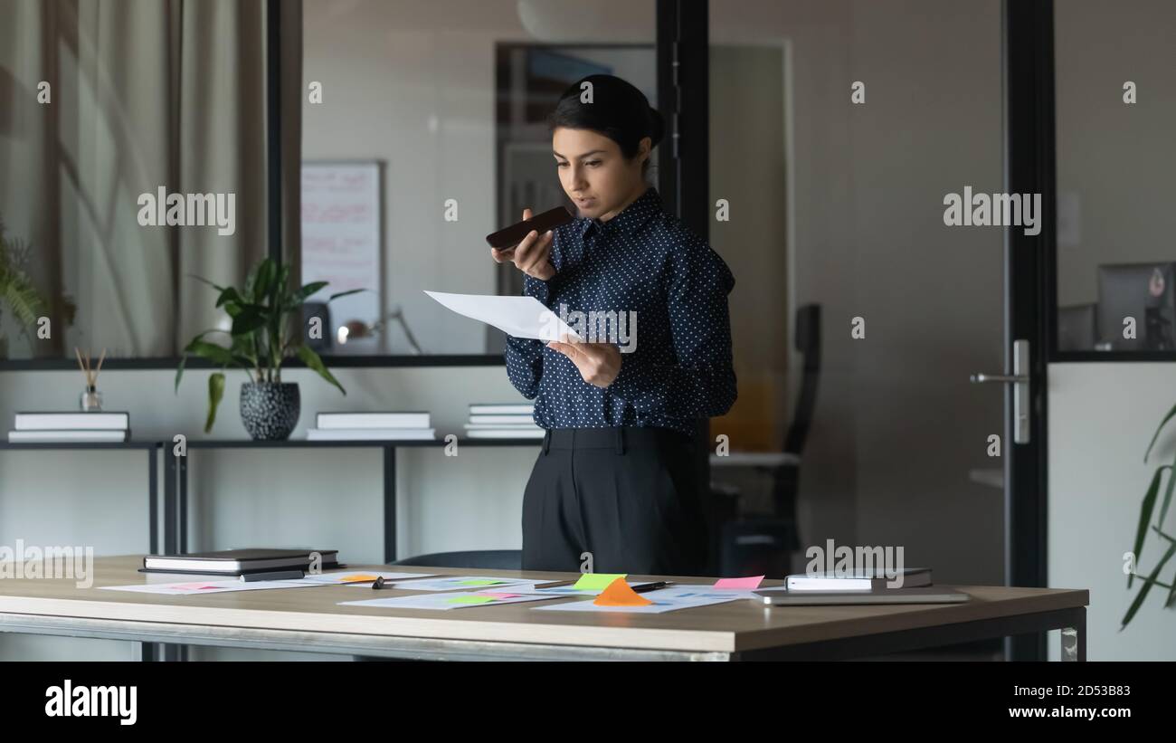 Young indian female employee talk on cell on speakerphone Stock Photo ...
