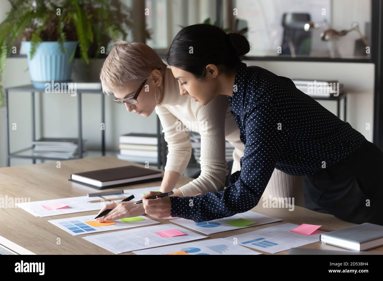 Multiracial female colleagues work with paper documents in office Stock ...