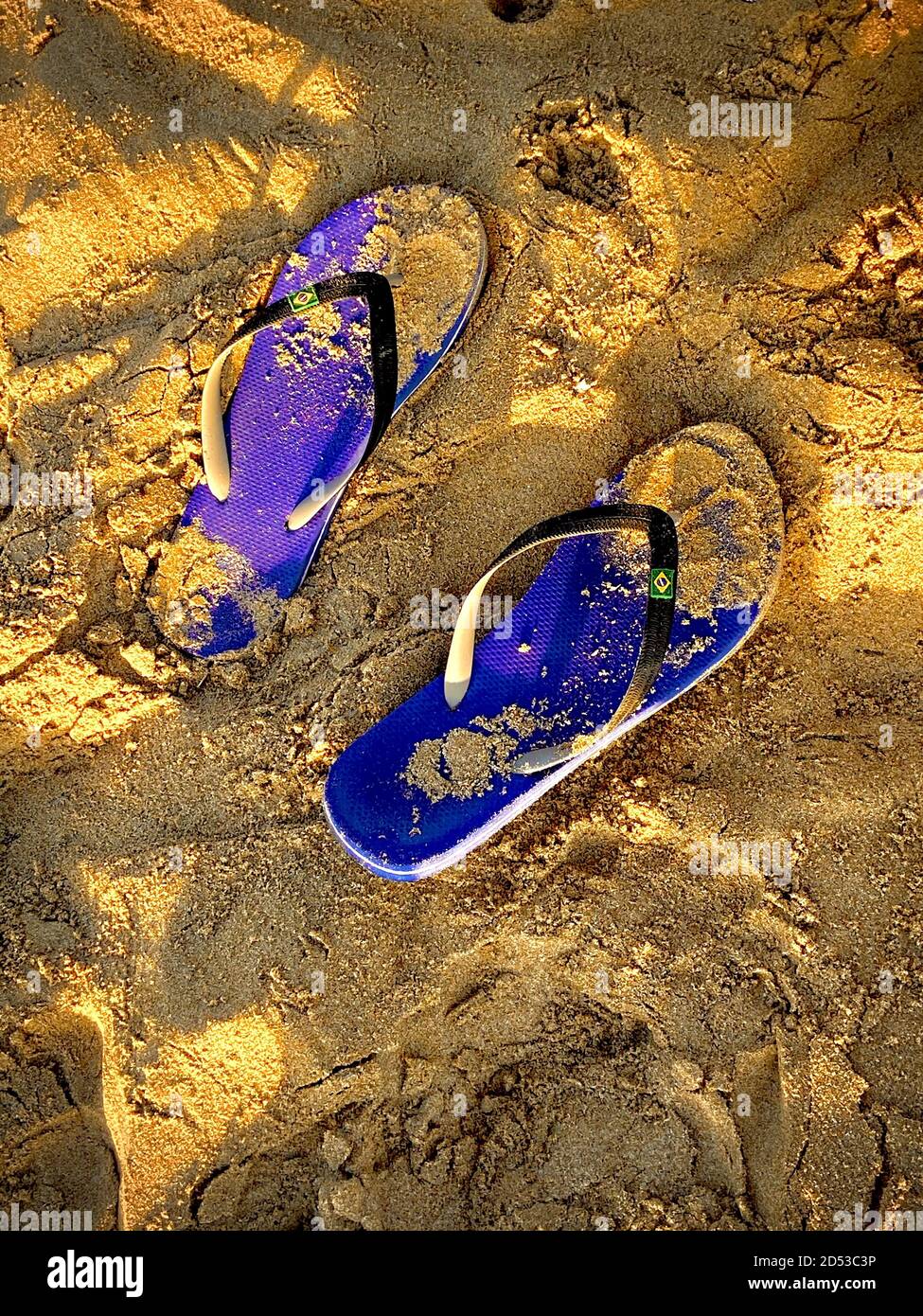 Vertical shot of flip flops on the sandy beach Stock Photo - Alamy