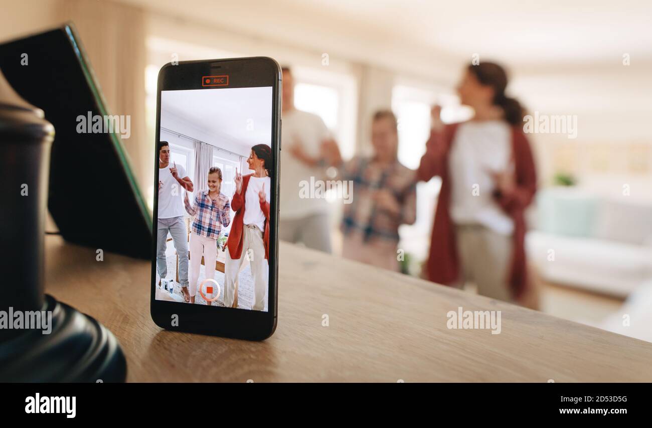 Family dancing in front of the phone indoors. Focus on mobile phone ...