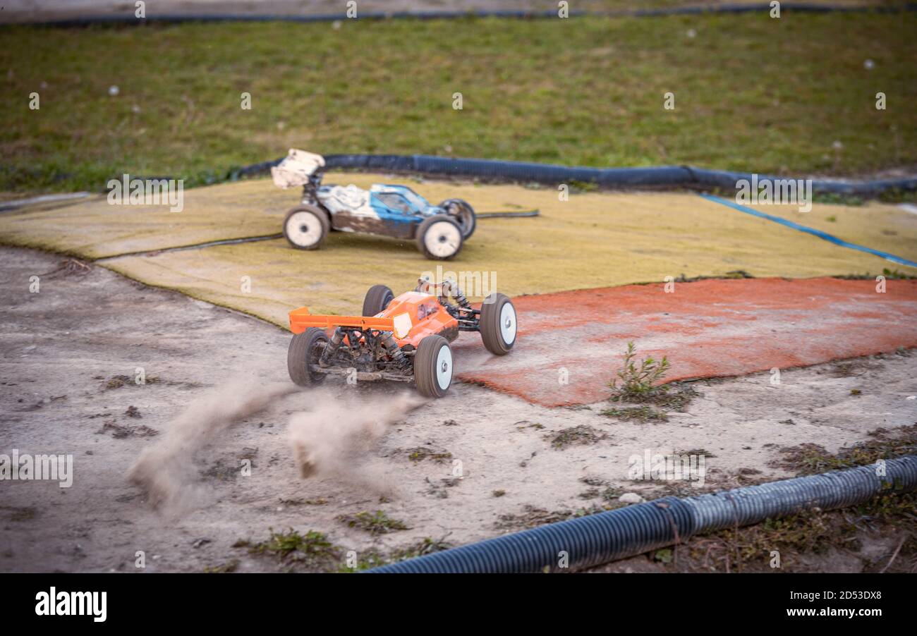 Orange RC buggy accelerating from a corner on an outdoor track Stock ...