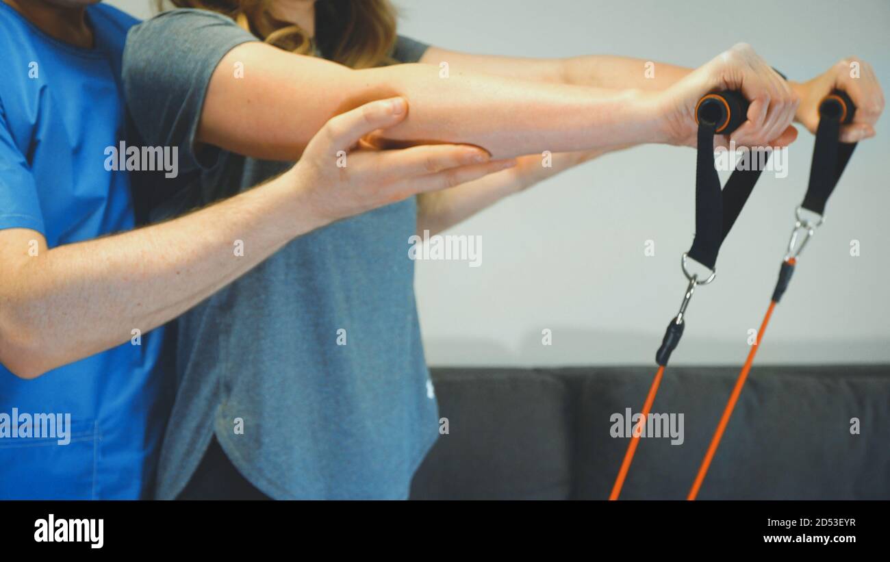 Physical therapist helping to do exercise with resistance bands ...