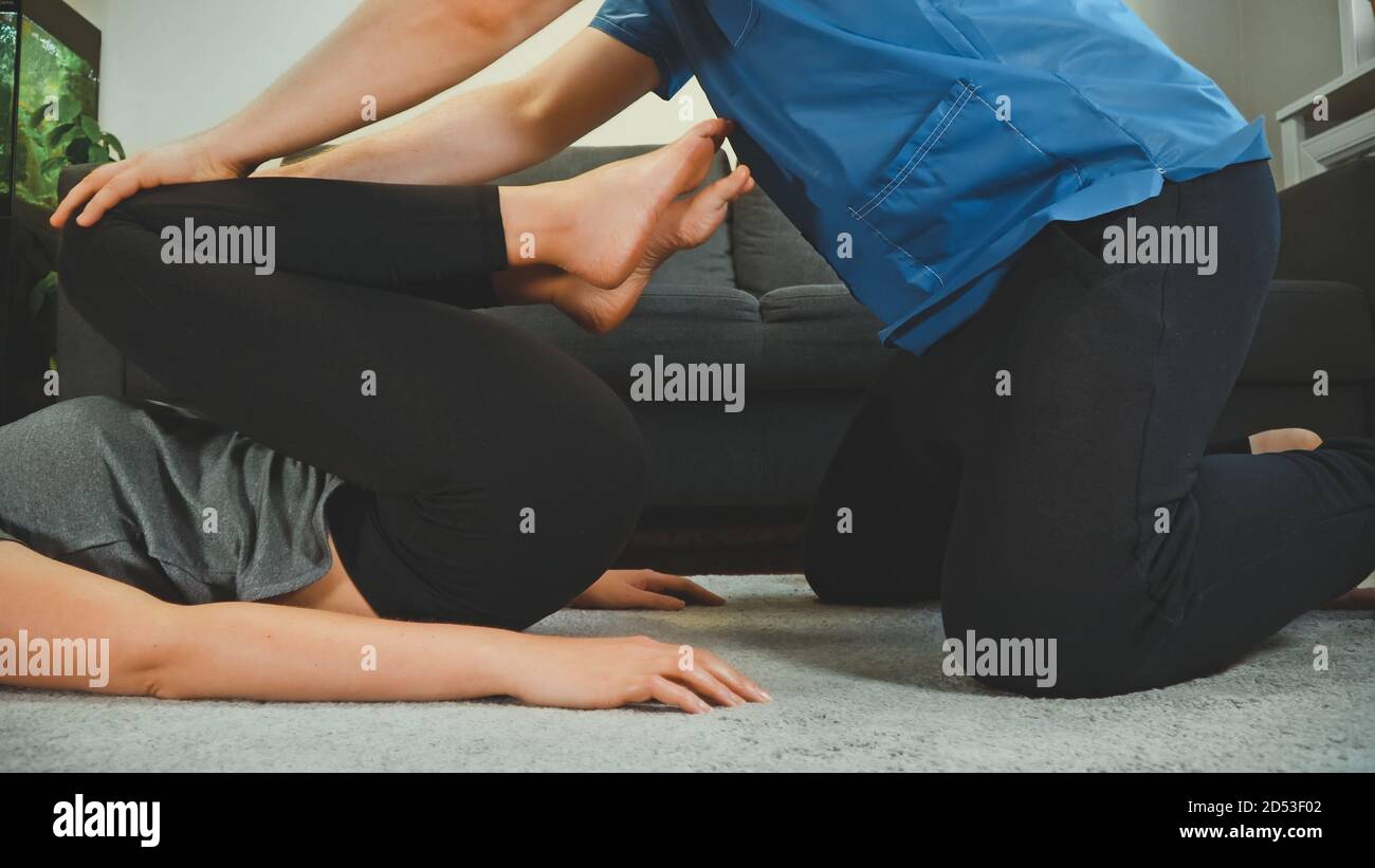 Therapist helping to do back exercise. Medical homecare Stock Photo - Alamy