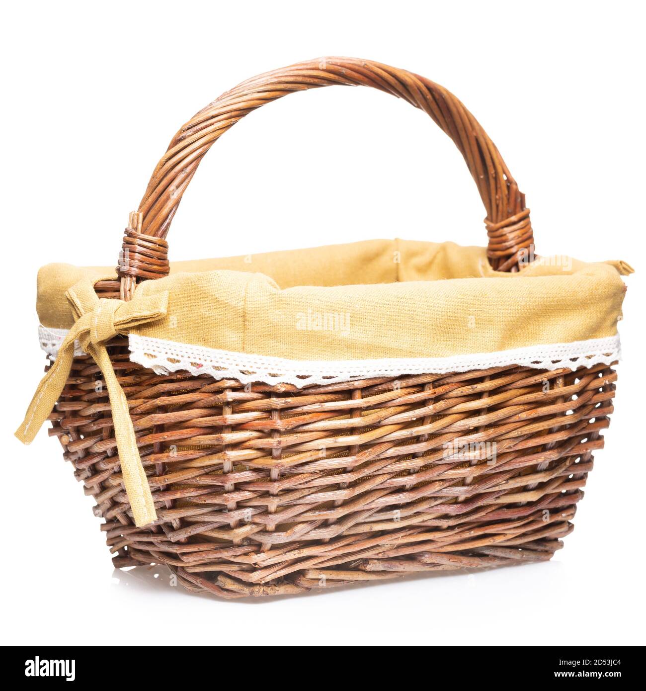 A wicker basket with a linen napkin inside and a bow Stock Photo - Alamy
