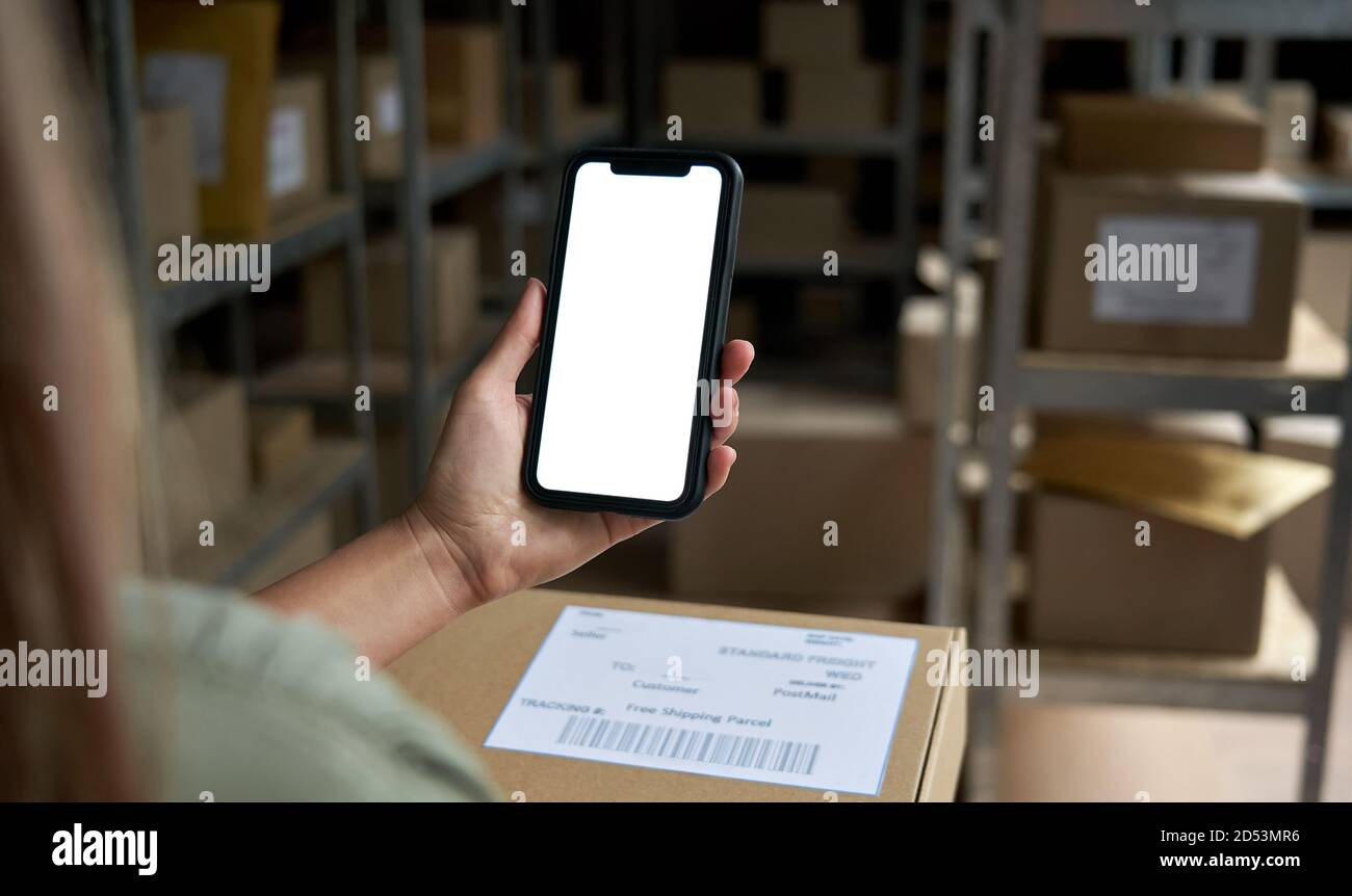 Female warehouse worker holding parcel box using mobile application ...