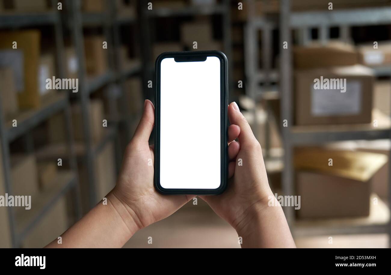 Female warehouse worker holding phone mobile application, mock up ...